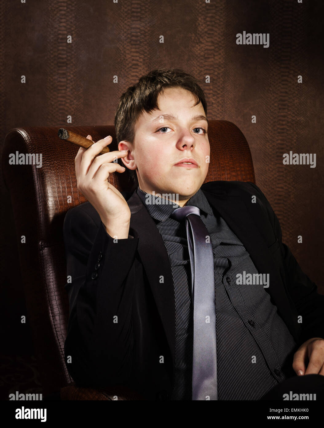 Young cigar smoker sitting in arm-chair, healthcare concept Stock Photo ...