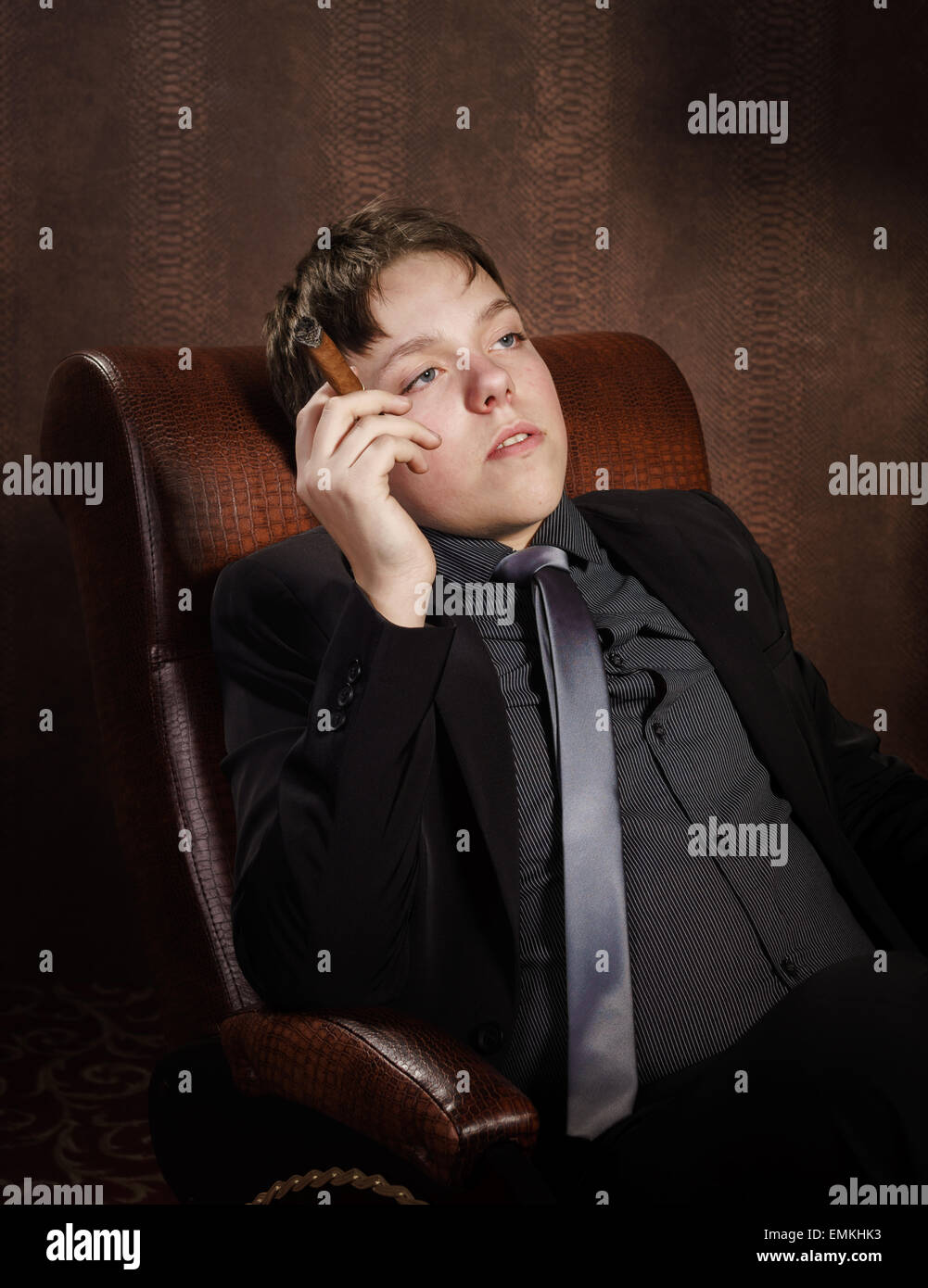 Young cigar smoker sitting in arm-chair, healthcare concept Stock Photo ...