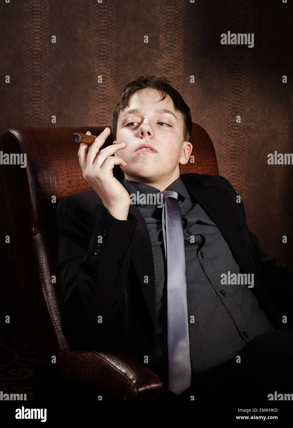 Young cigar smoker sitting in arm-chair, healthcare concept Stock Photo ...