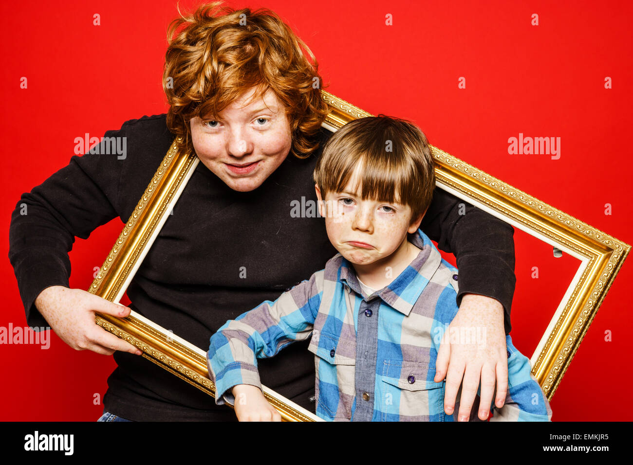 Two expressive brothers studio portrait, red-haired boys isolated on ...