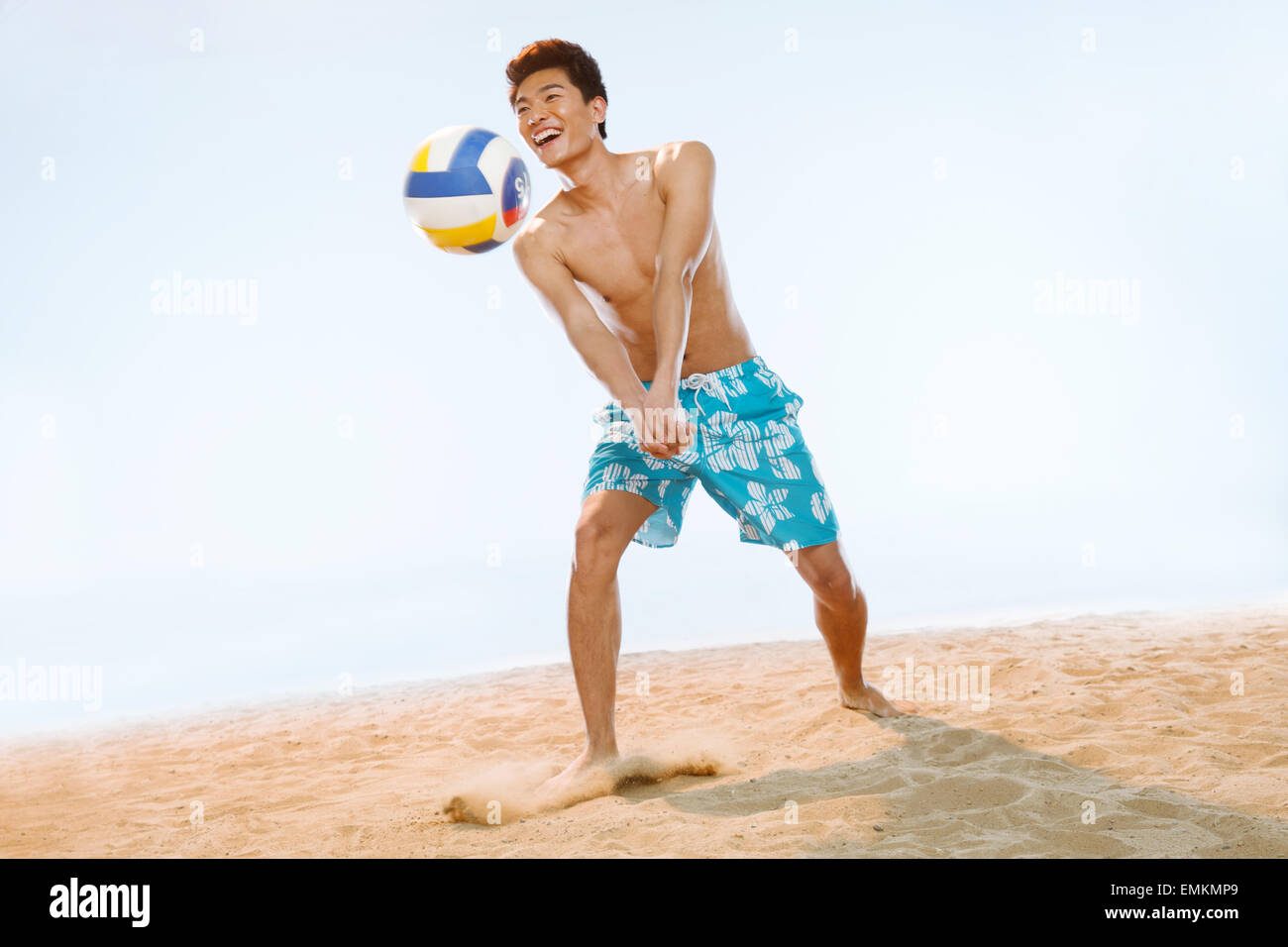 A young man playing volleyball Stock Photo - Alamy