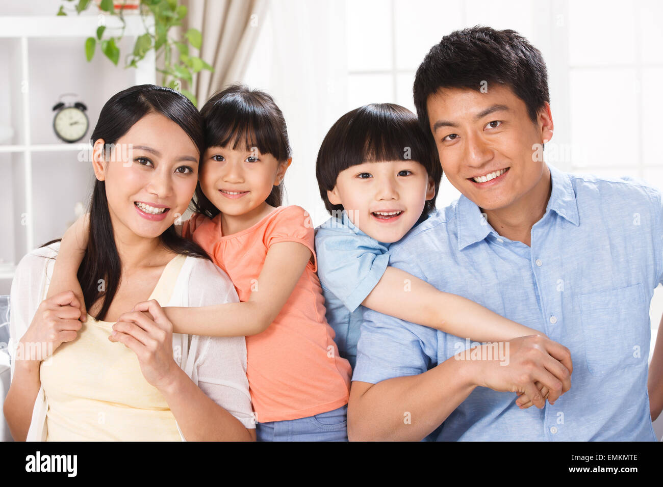 The happiness of a family of four in the living room Stock Photo - Alamy