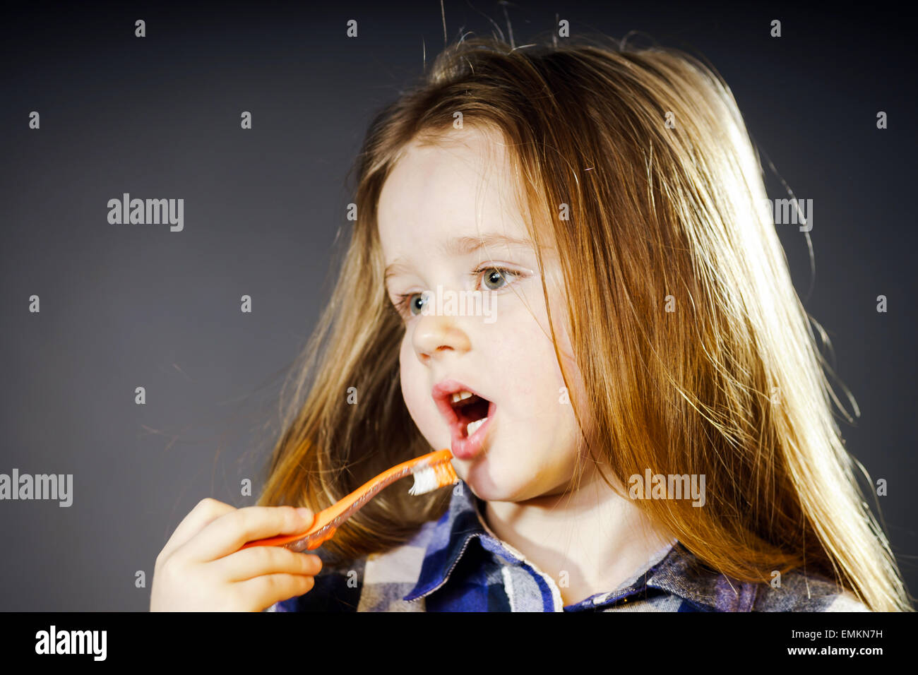 Cute little girl cleaning the teeth, isolated on dark background Stock ...
