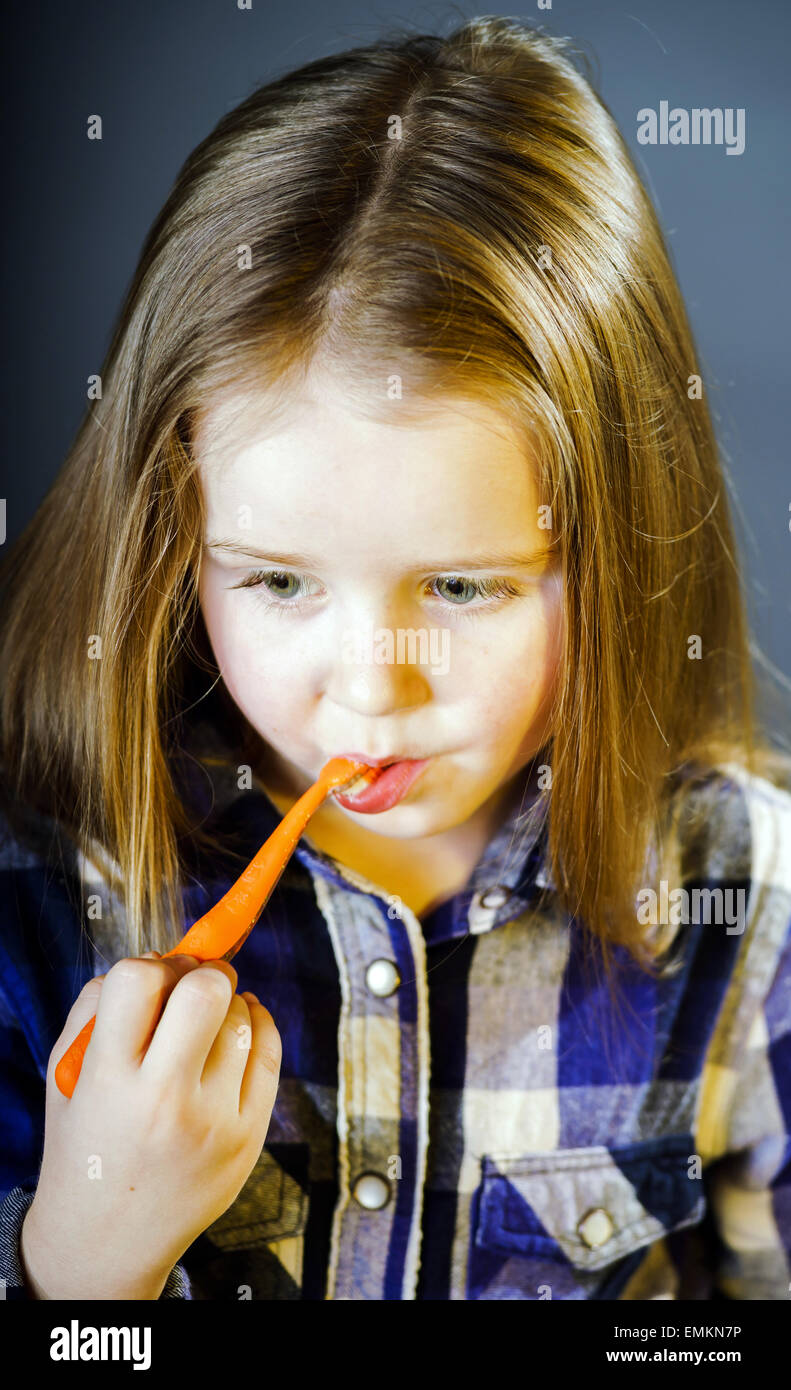 Cute little girl cleaning the teeth, isolated on dark background Stock ...