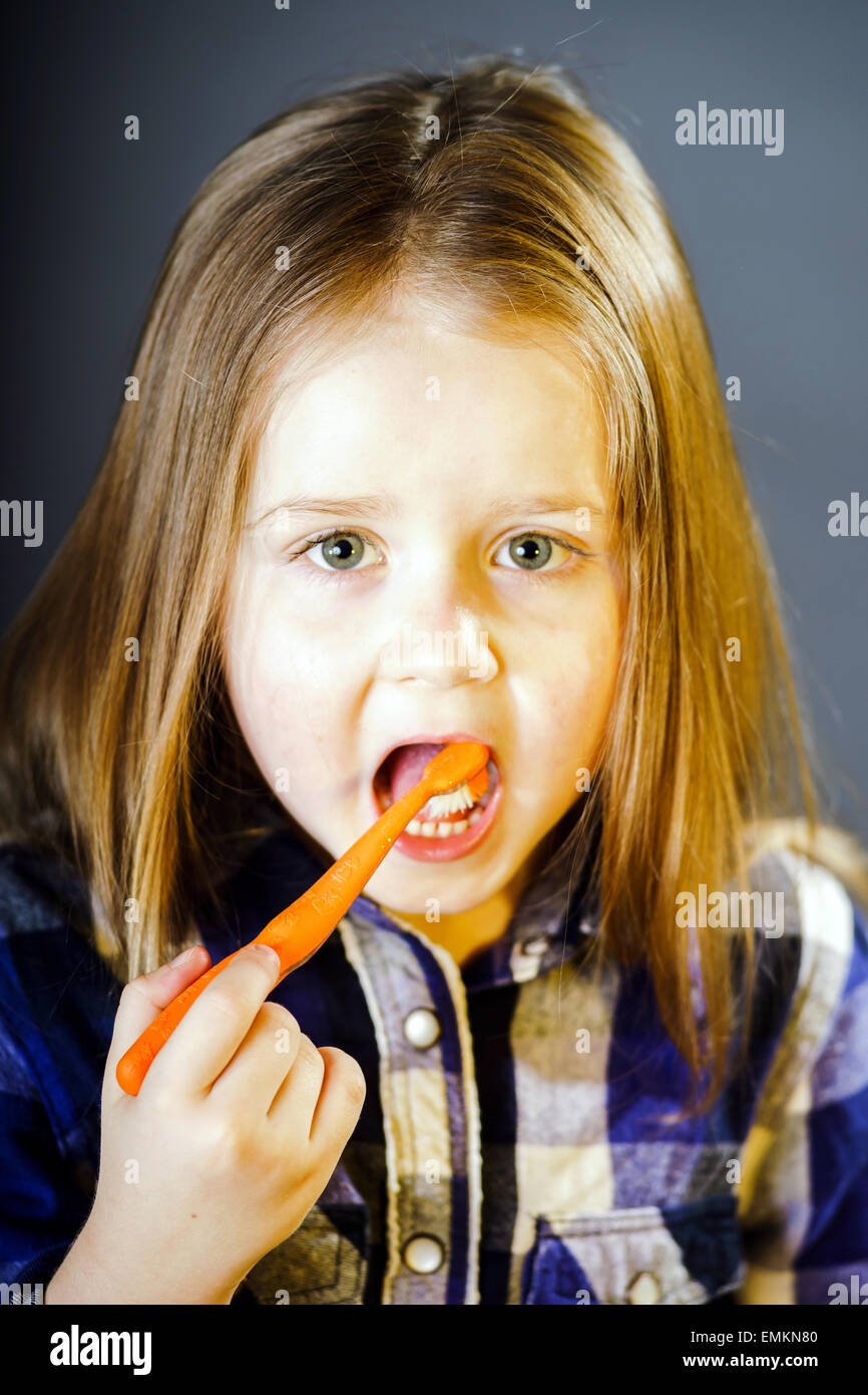 Cute little girl cleaning the teeth, isolated on dark background Stock ...