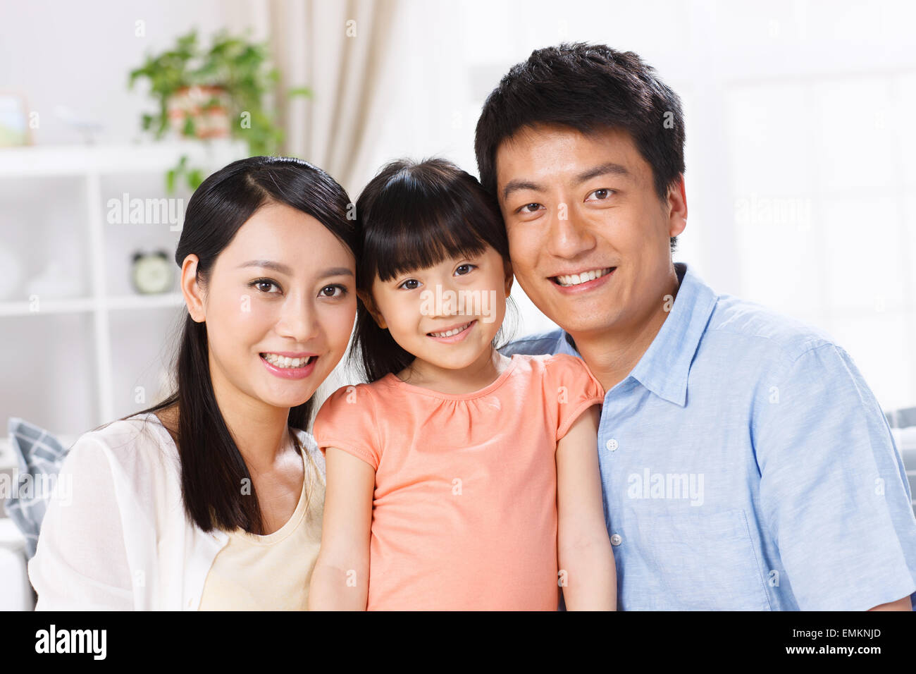 Happy family of three in the living room Stock Photo - Alamy