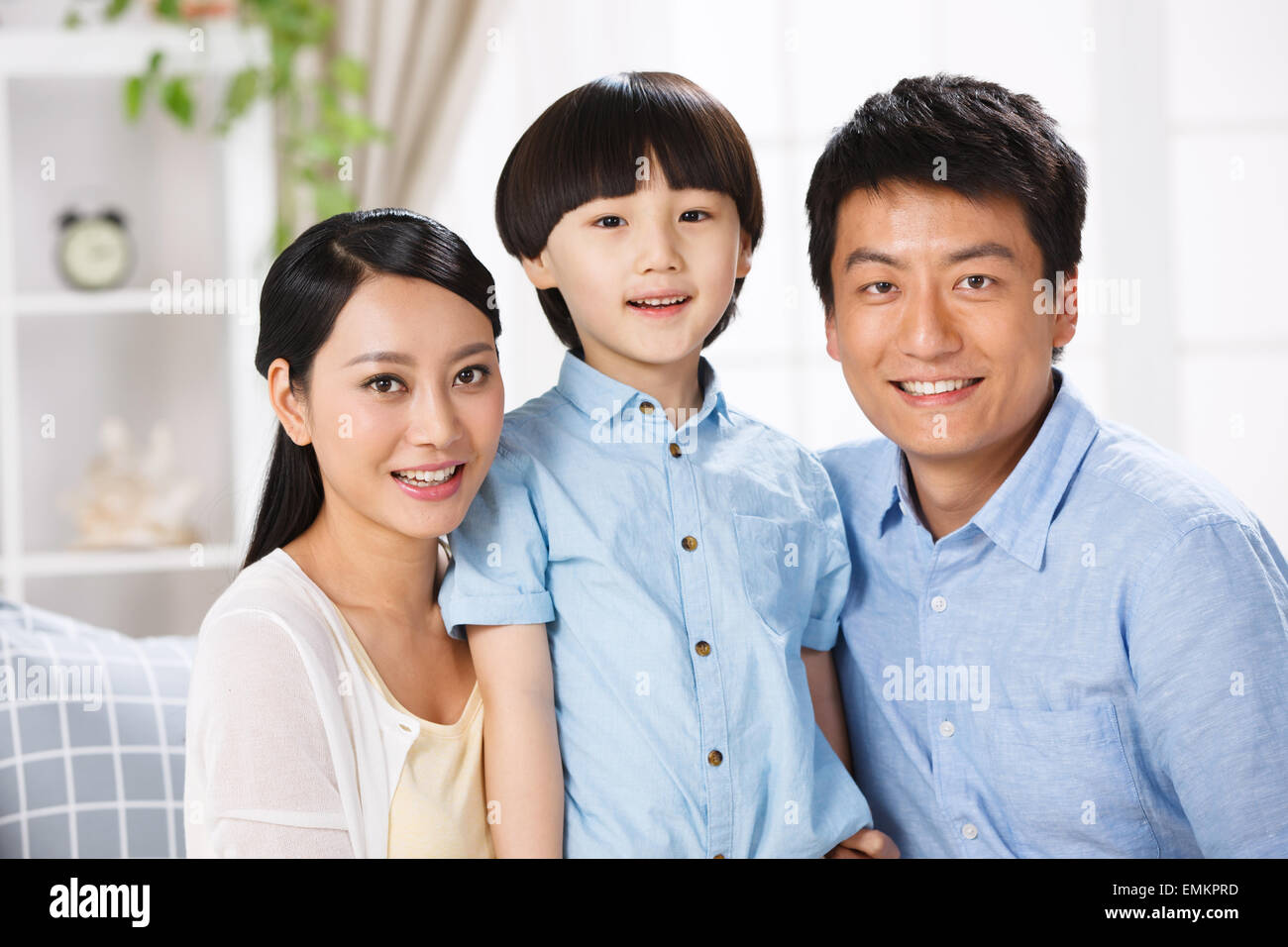 Happy family of three in the living room Stock Photo - Alamy