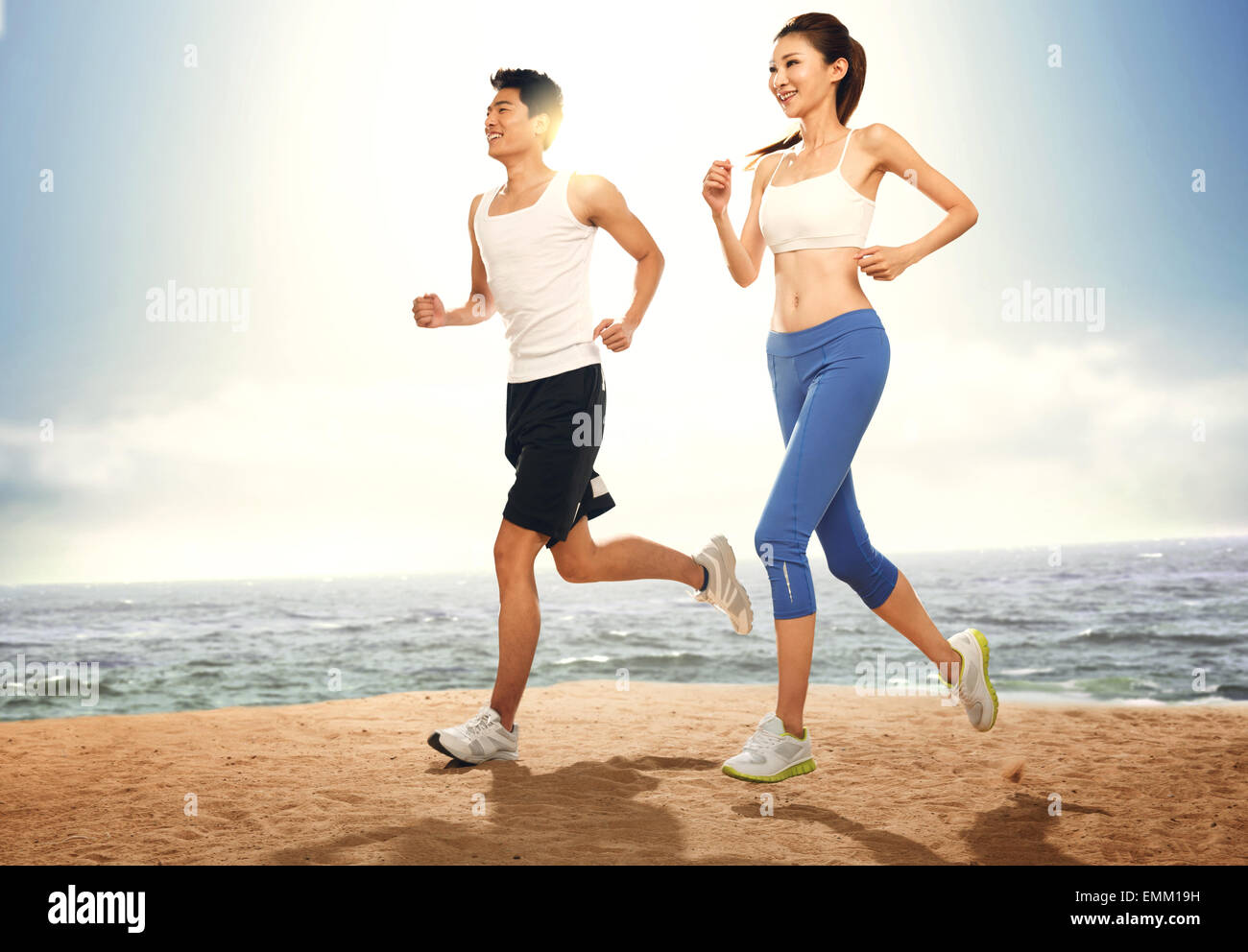 The young couple running on the beach Stock Photo - Alamy