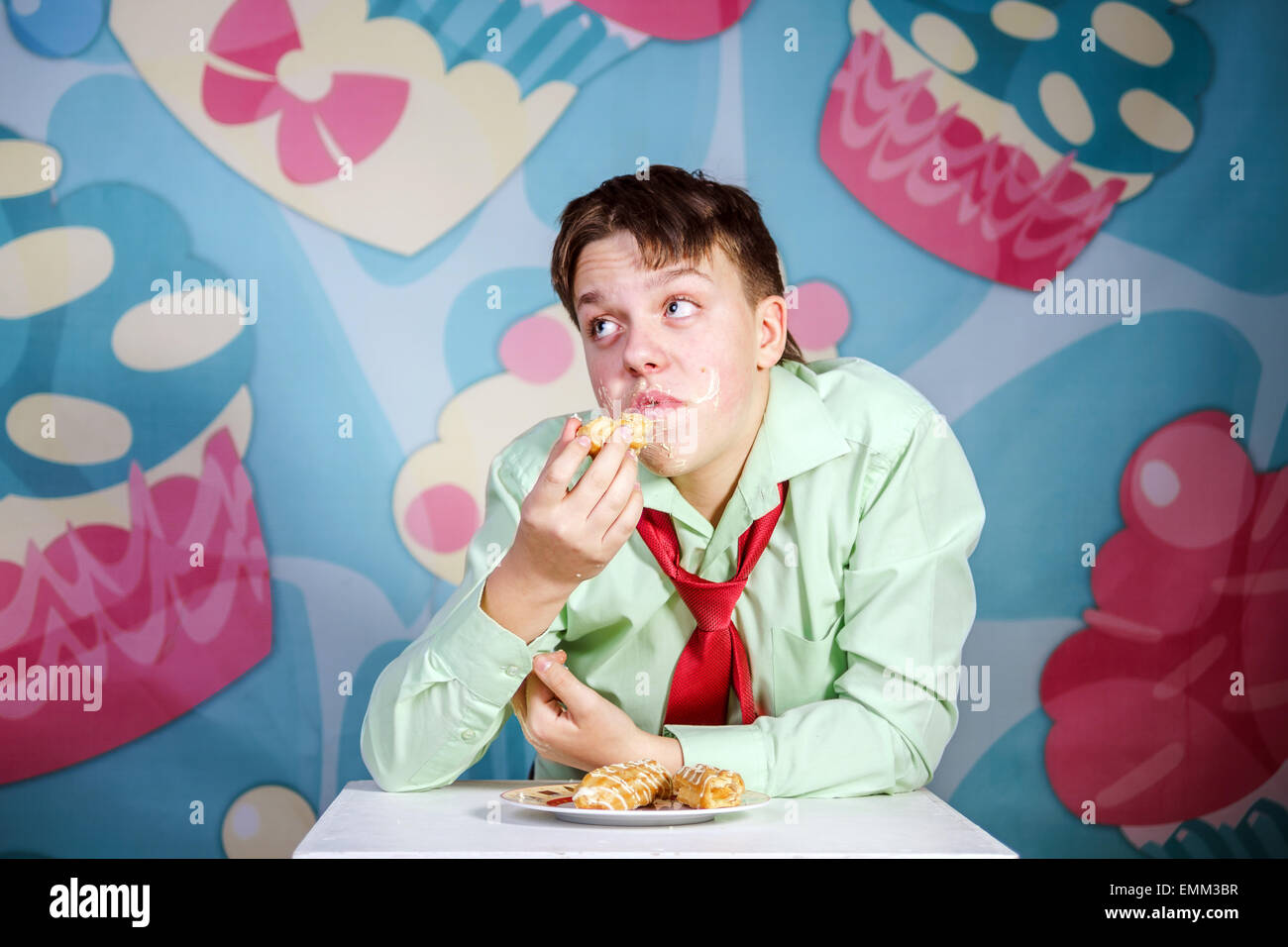 Funny teenage boy eating sweet cakes, hungry and candy man Stock Photo ...