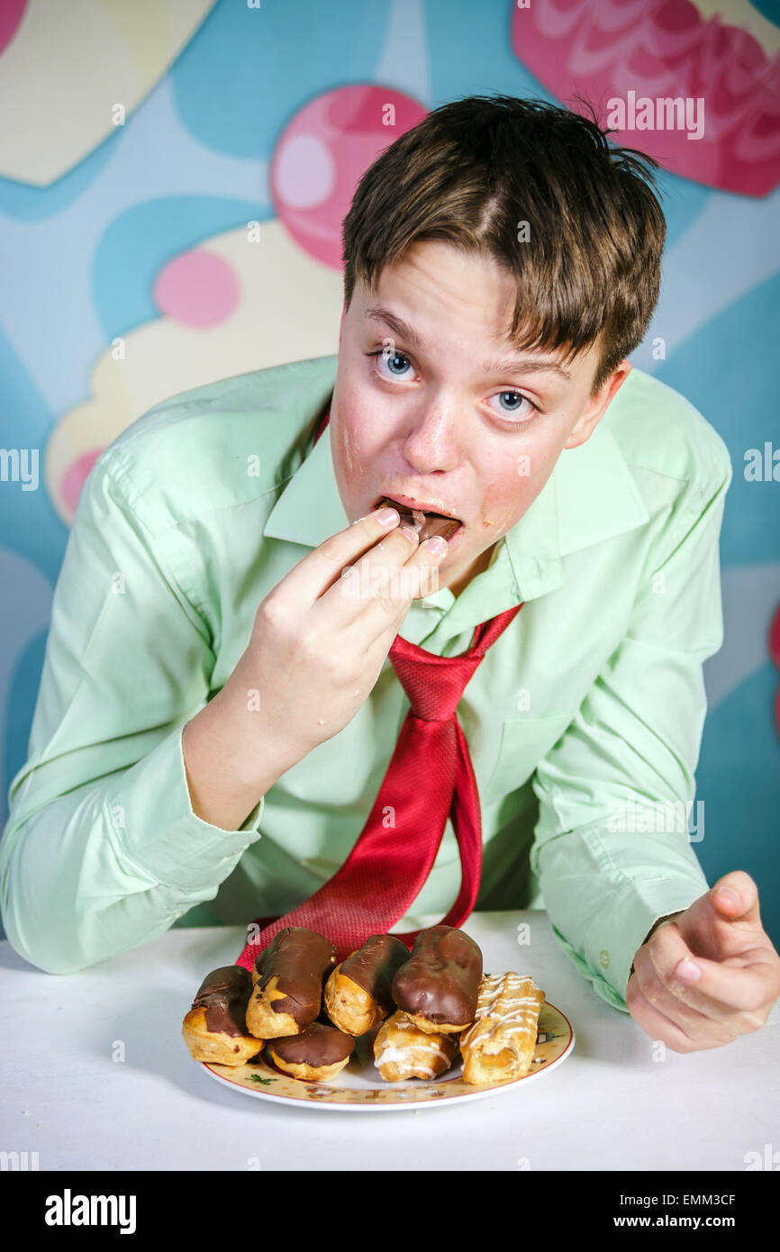 Funny teenage boy eating sweet cakes, hungry and candy man Stock Photo ...