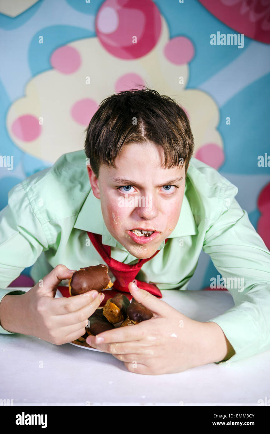Funny teenage boy eating sweet cakes, hungry and candy man Stock Photo ...