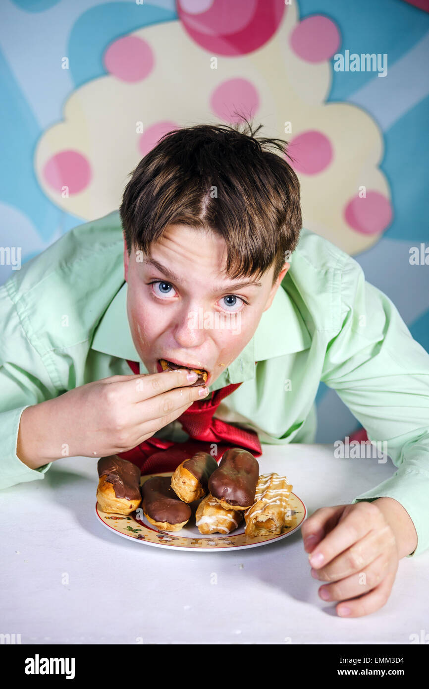 Funny teenage boy eating sweet cakes, hungry and candy man Stock Photo ...
