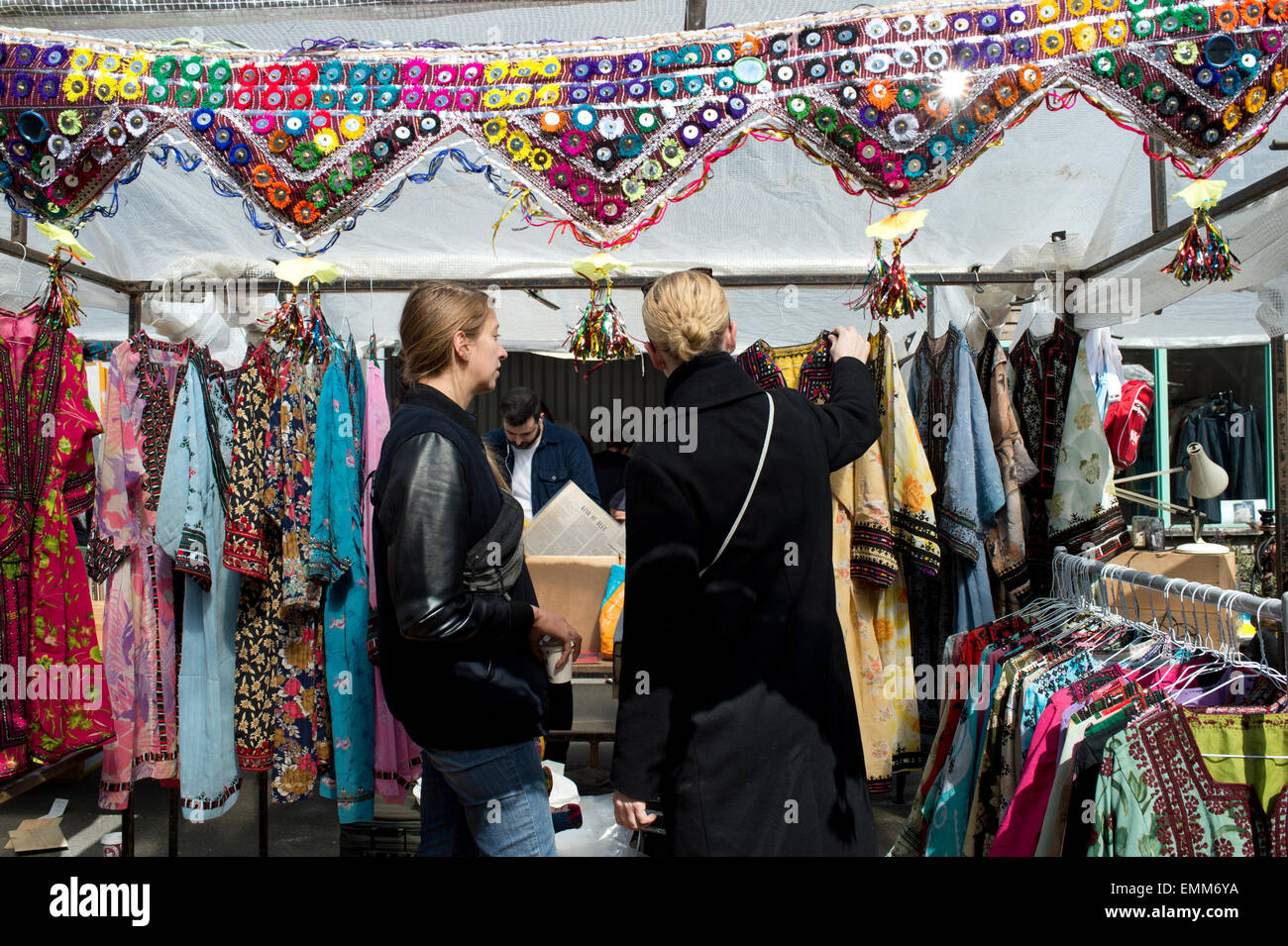 Netil market, women inspect dresses at a stall with clothes and painted ...