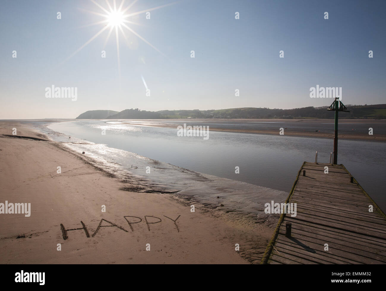 "Happy" written in the sands on the beach suuny day at Ferryside with ...