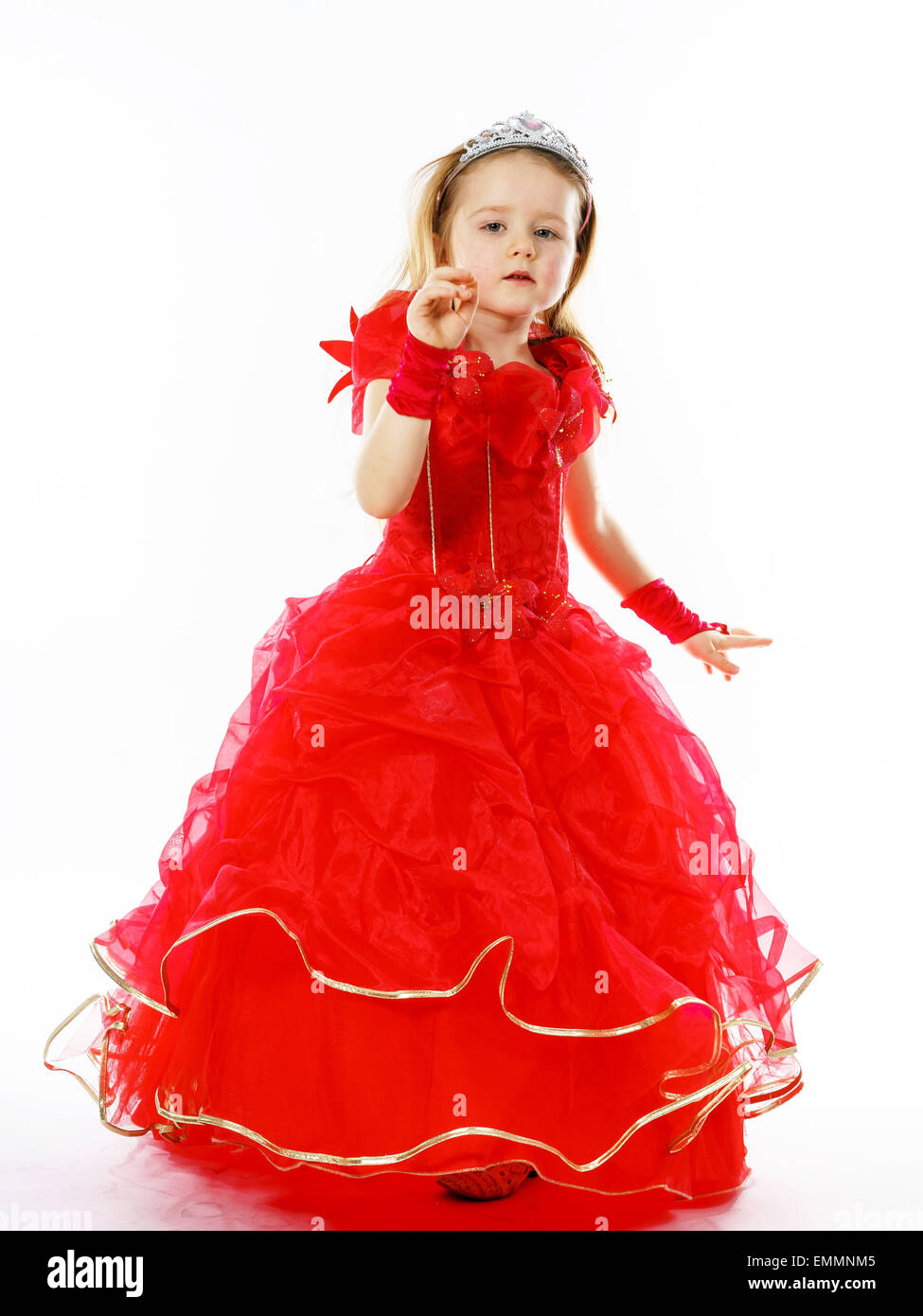 Cute little princess dressed in red with crown on her head posing in ...