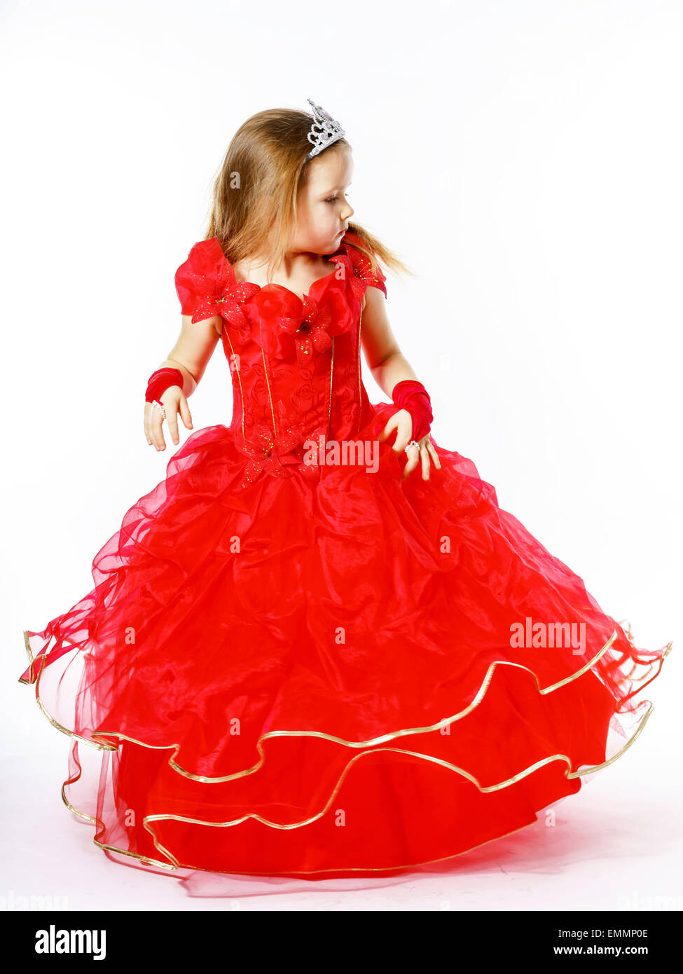 Cute little princess dressed in red with crown on her head posing in ...