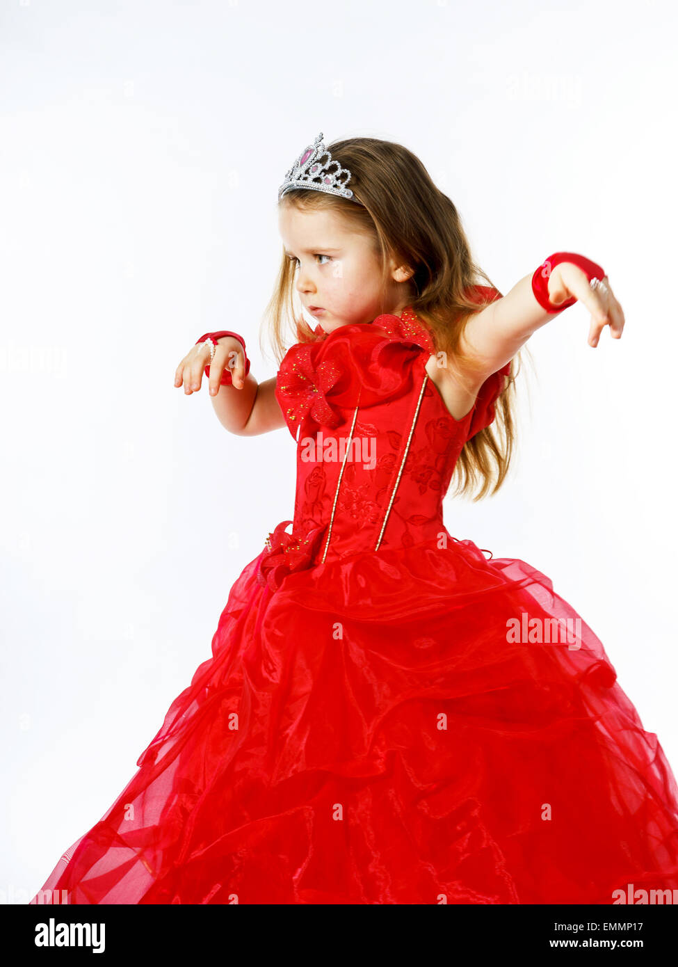 Cute little princess dressed in red with crown on her head posing in ...