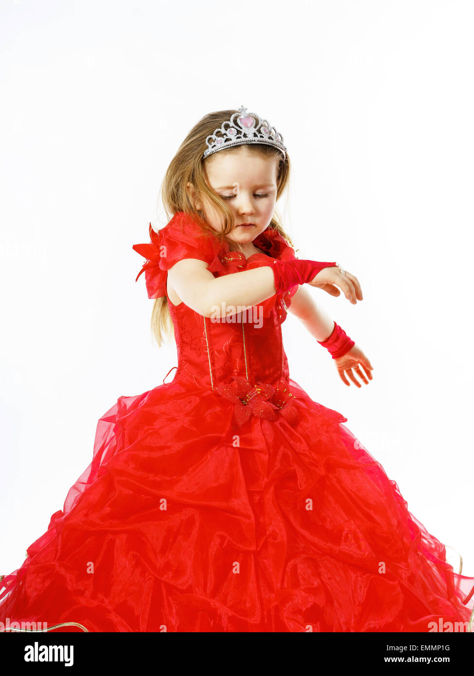 Cute little princess dressed in red with crown on her head posing in ...