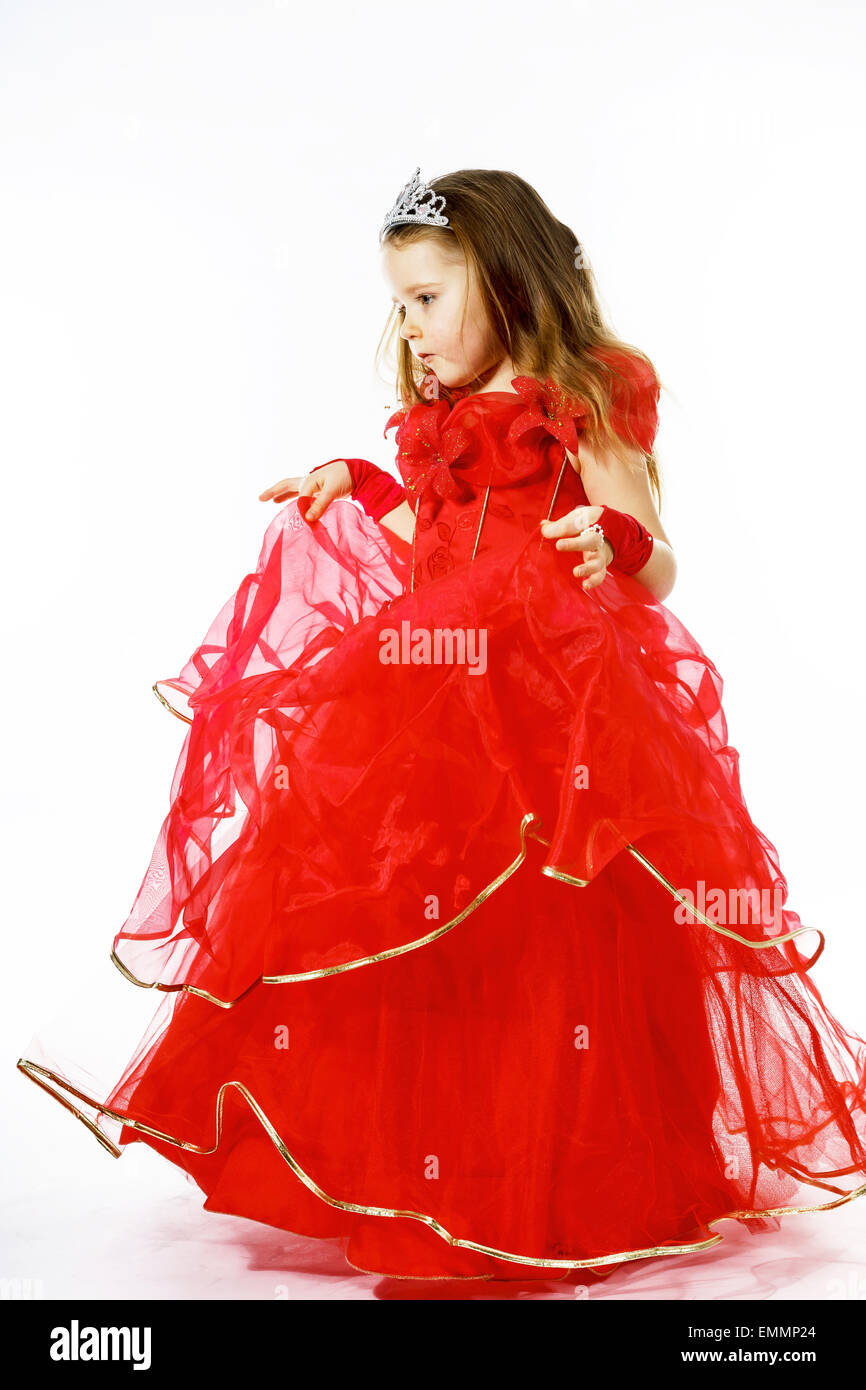 Cute little princess dressed in red with crown on her head posing in ...
