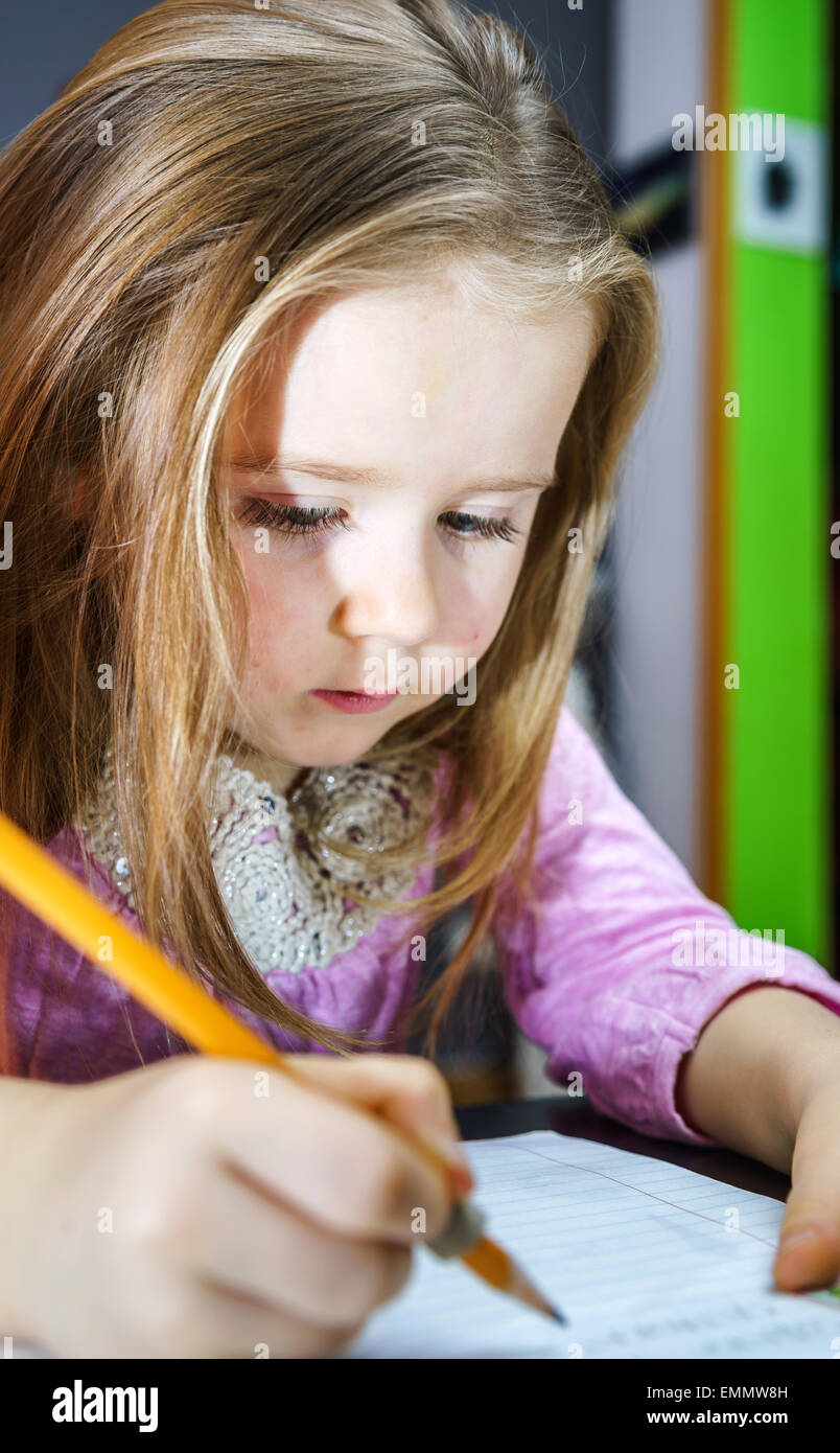Cute little girl studing to speaking and writing letters at home lesson ...