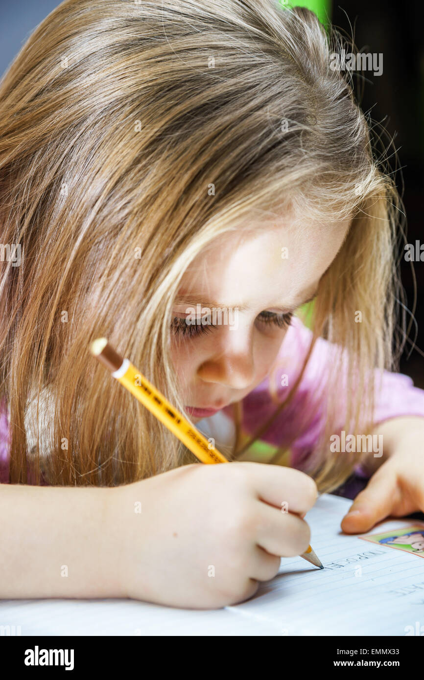Cute little girl studing to speaking and writing letters at home lesson ...