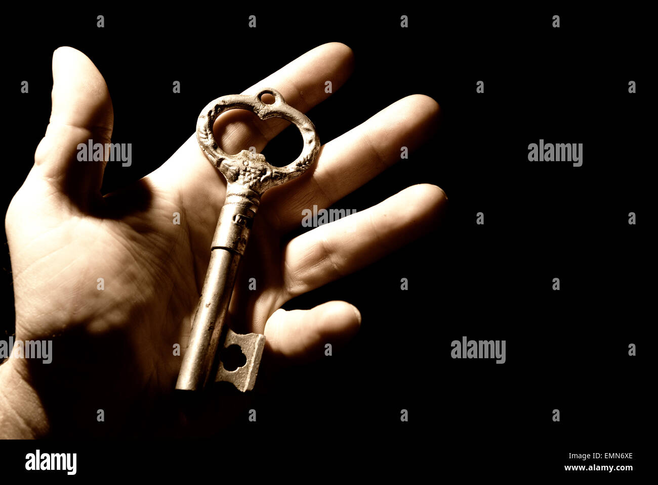 Human hand with an old key isolated on black background Stock Photo - Alamy