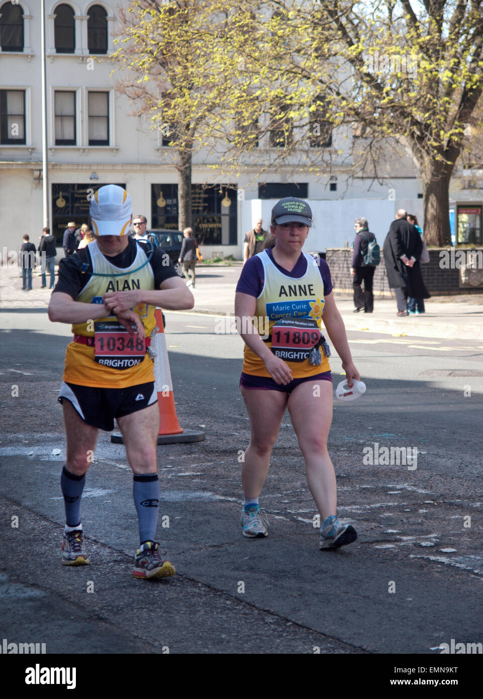 Exhausted marathon runners slowly make their way to the finishing line ...