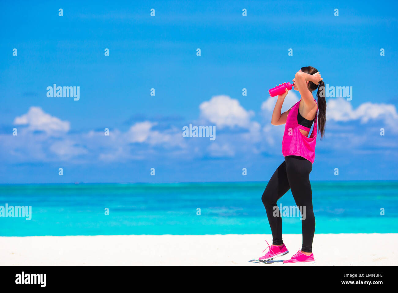 Fit young woman doing exercises on tropical white beach in her ...