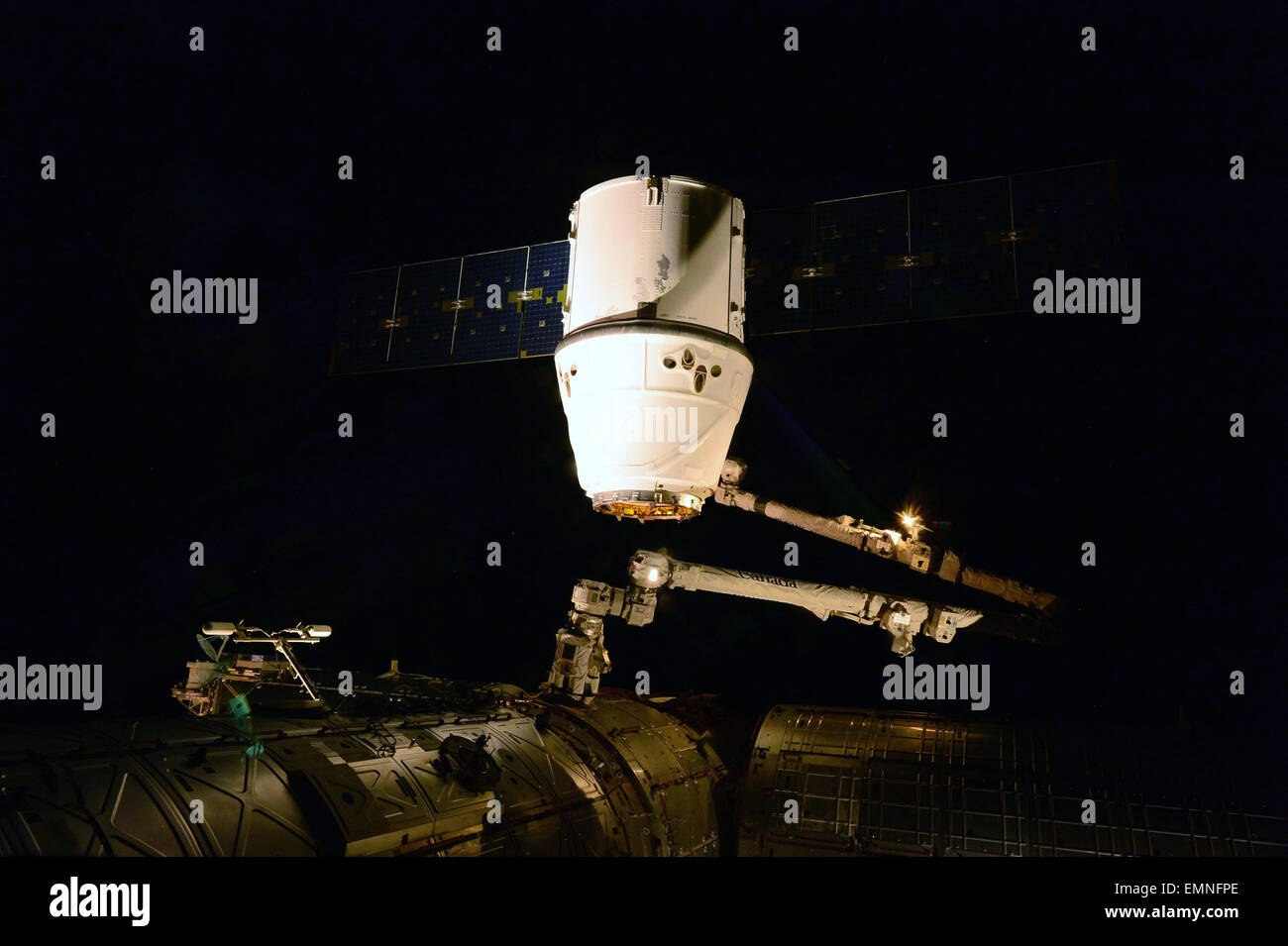 The Canadarm 2 pulls the SpaceX Dragon cargo spacecraft into port on ...