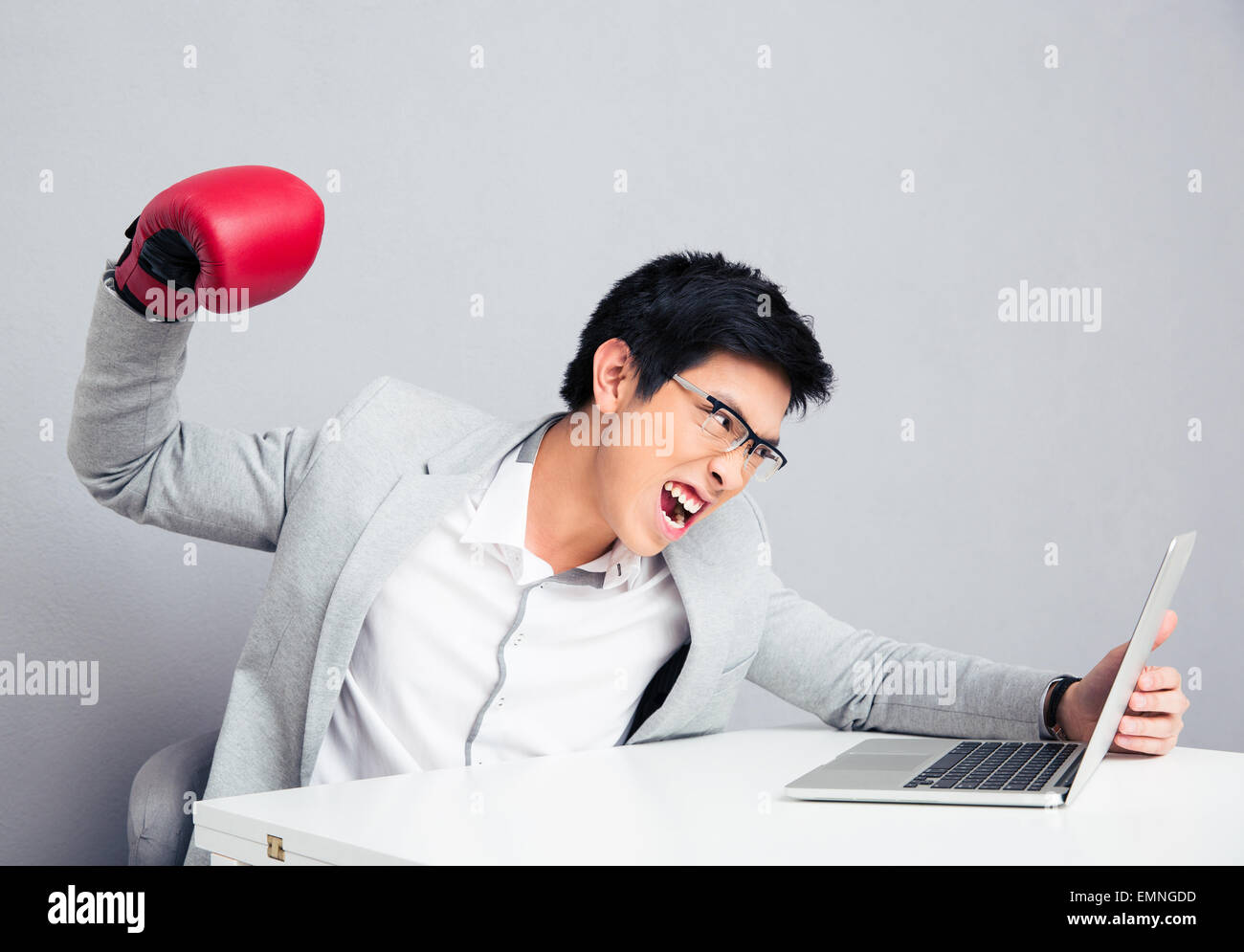 Angry young businessman sitting at the table and reading to hit the ...