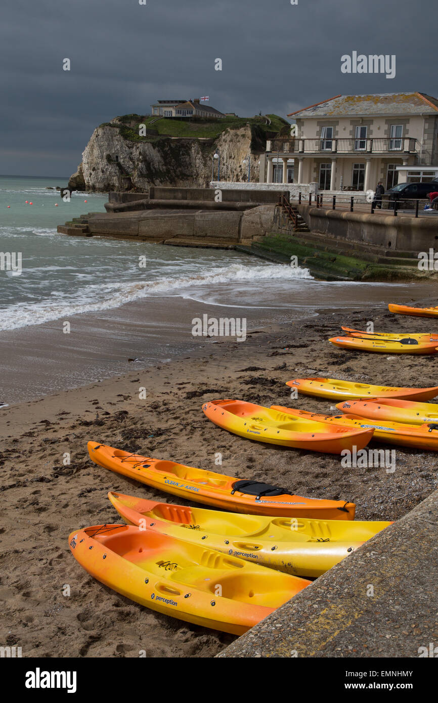 Bright orange canoes line up along the beach before a storm on the Isle ...