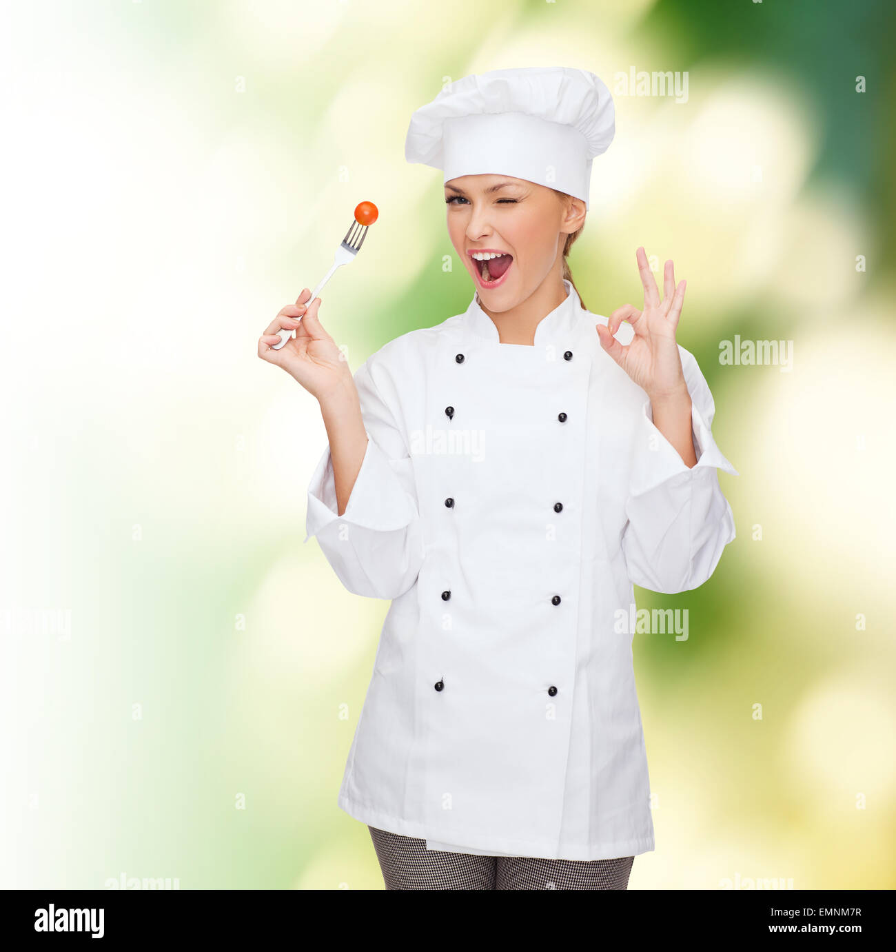 smiling female chef with fork and tomato Stock Photo - Alamy