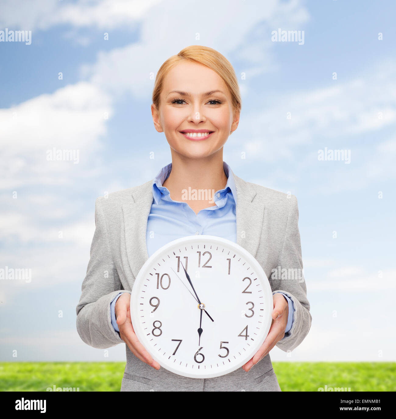 smiling businesswoman with wall clock Stock Photo - Alamy