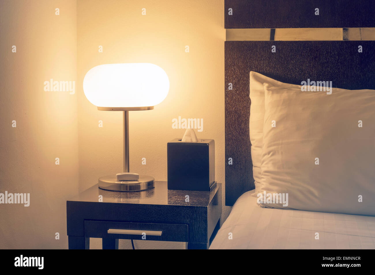 bedroom interior with illuminated bed light on wooden table Stock Photo ...