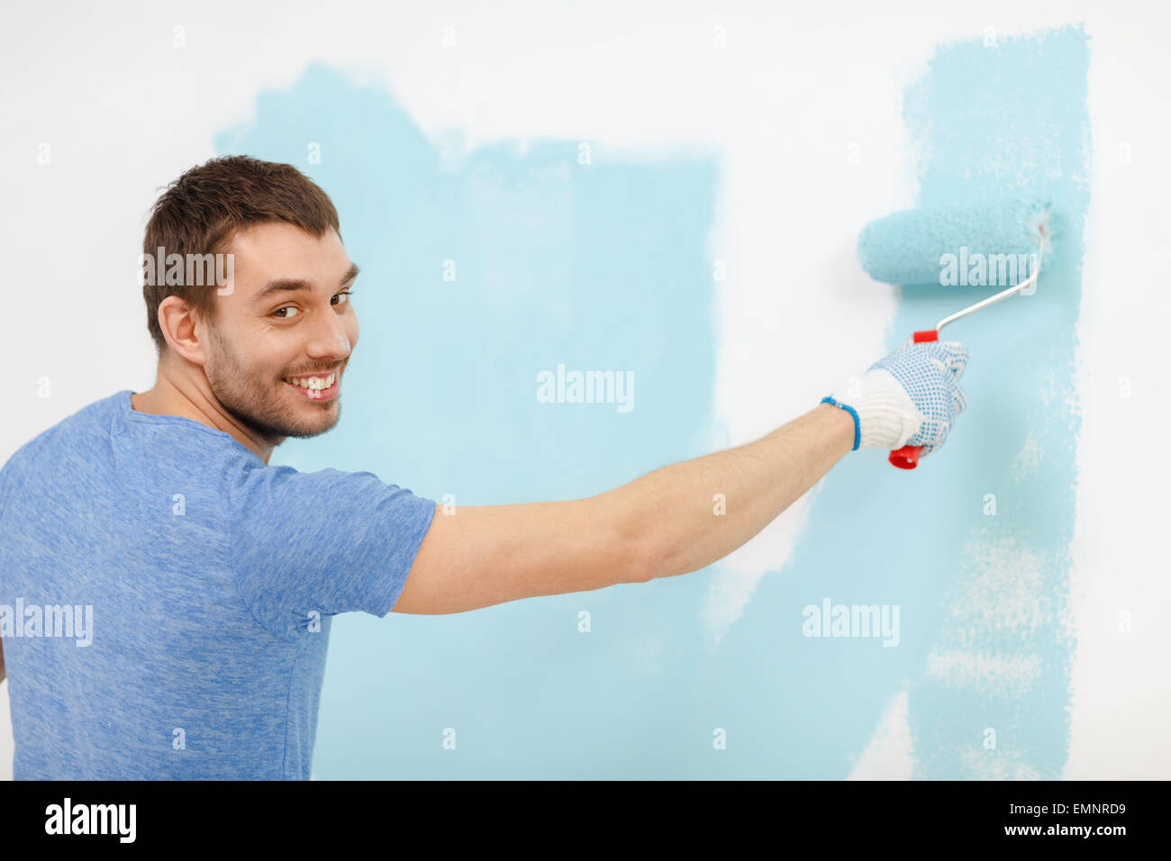 smiling man painting wall at home Stock Photo - Alamy