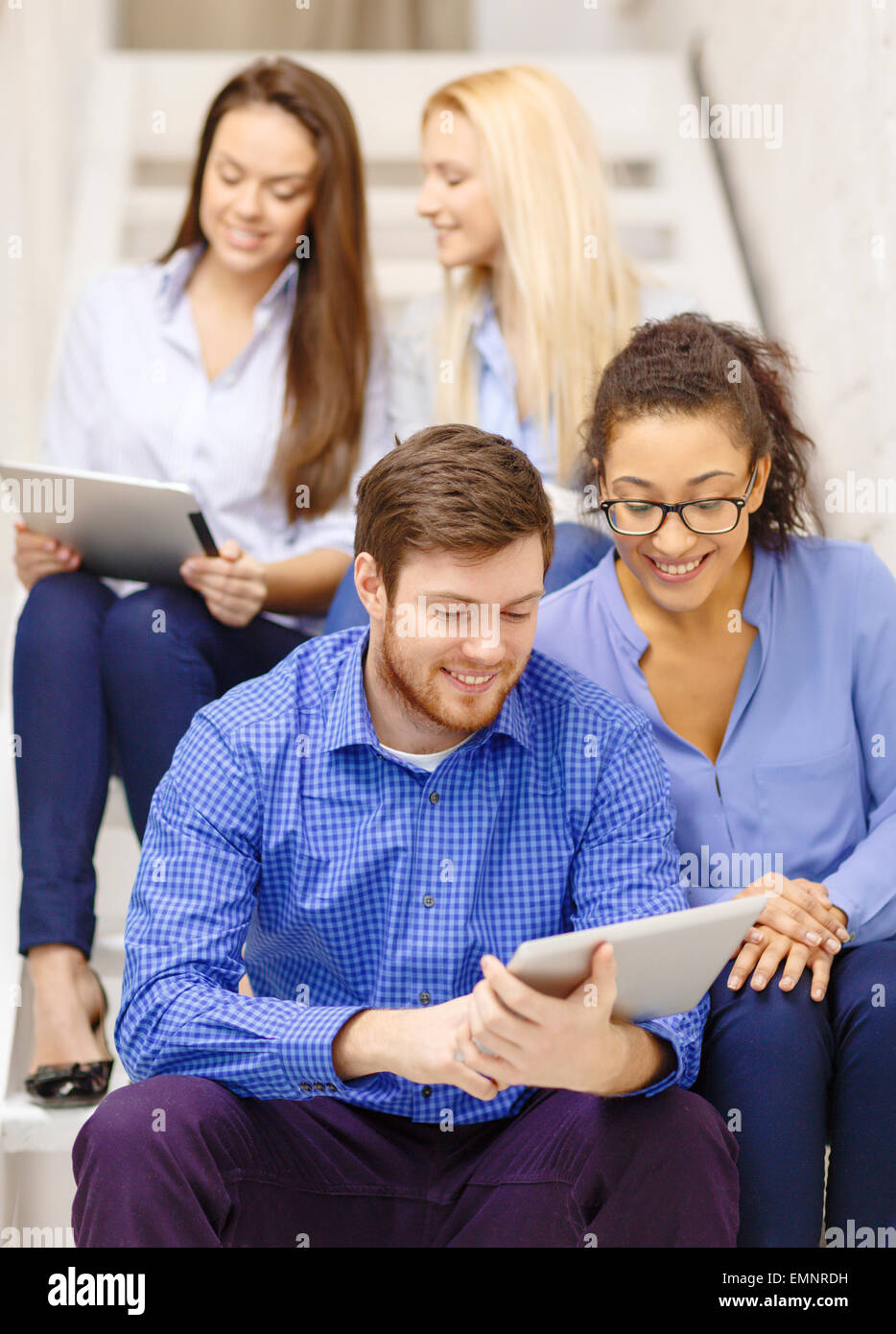team with tablet pc computer sitting on staircase Stock Photo - Alamy
