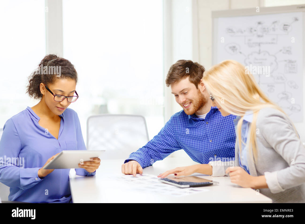 smiling team with table pc and papers working Stock Photo - Alamy