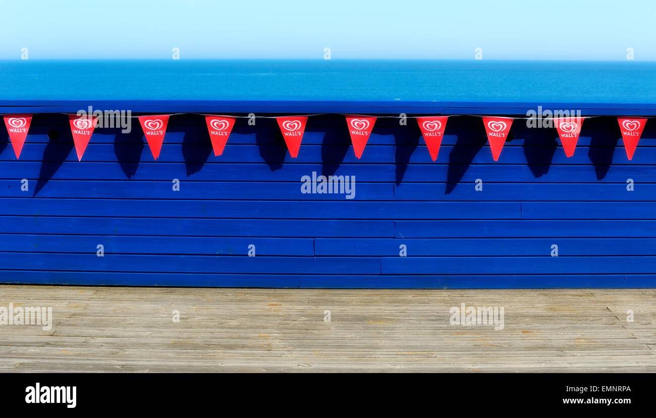 Walls ice cream flag bunting on a blue fence in an outdoor cafe England ...