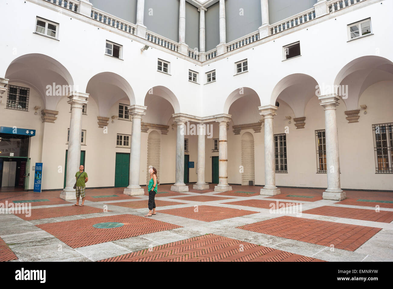 Genoa museum, tourists in the Palazzo Ducale in Genoa pause to study ...