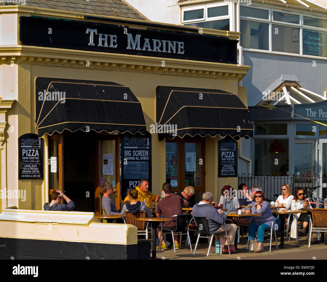 Customers enjoying a drink in sunshine outside The Marine pub in ...