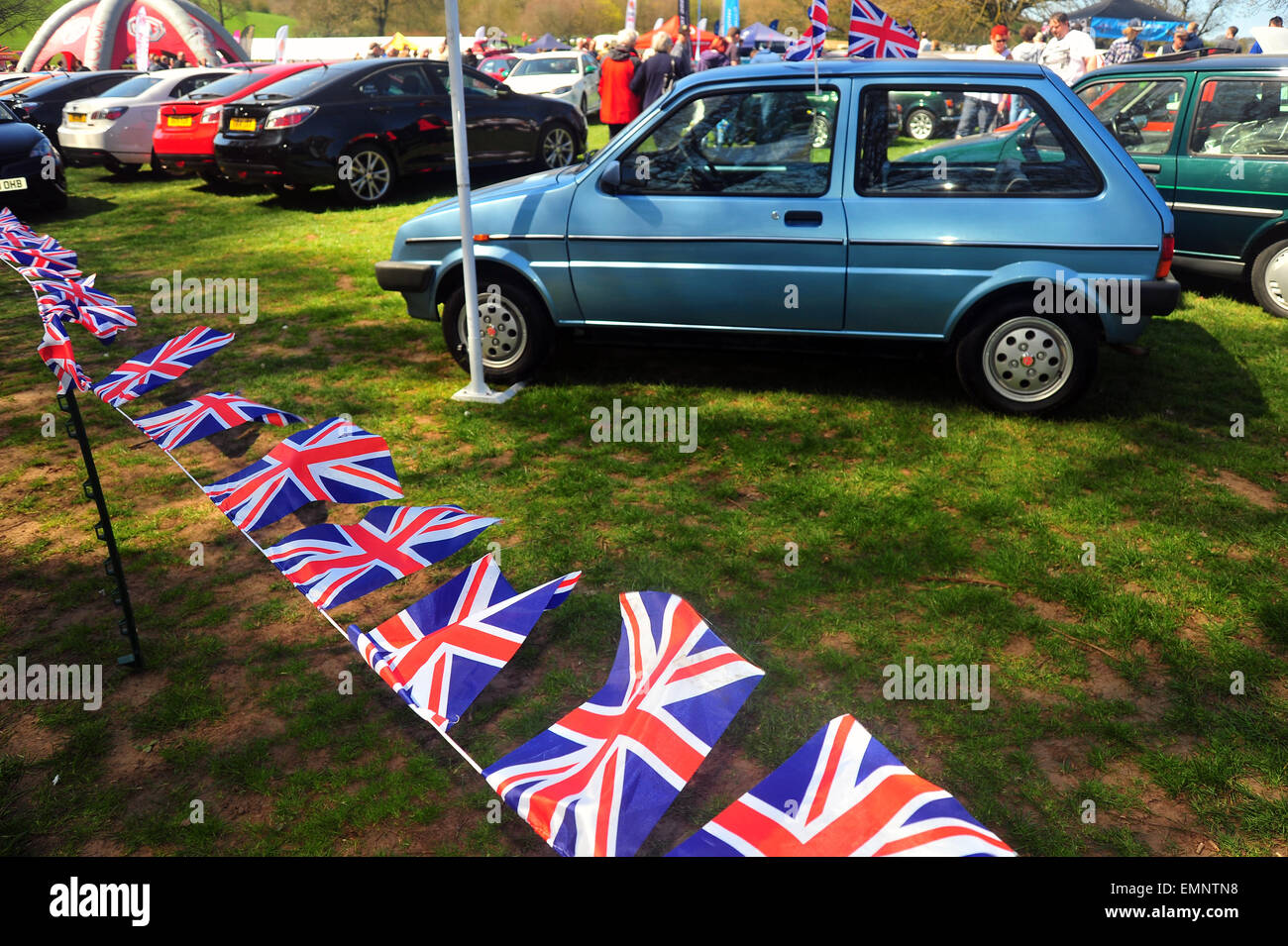 A row of mini Union Jack flags blow in the wind at a classic car show ...