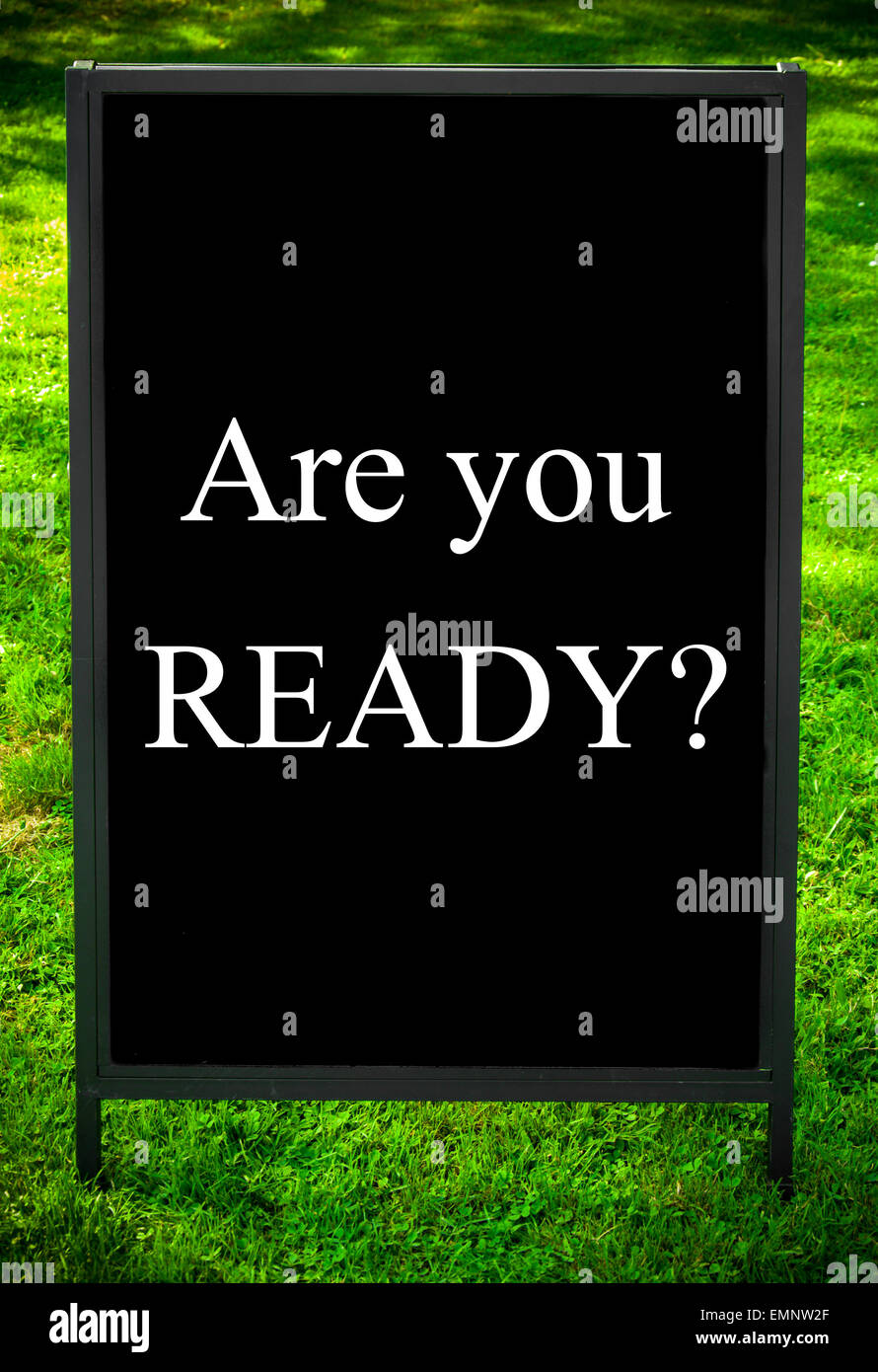 ARE YOU READY? message on sidewalk blackboard sign against green grass ...