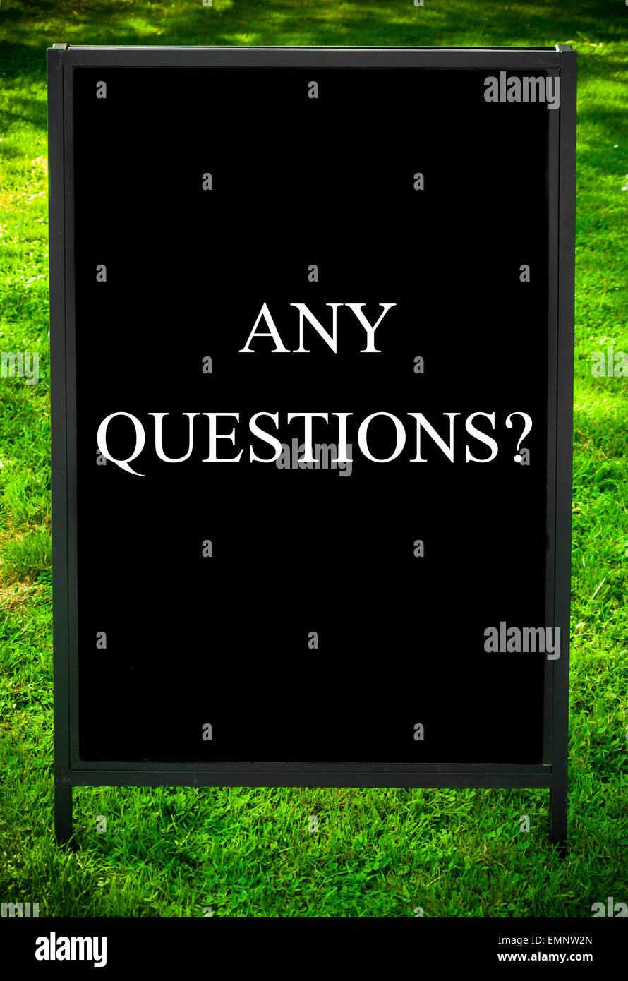 ANY QUESTIONS? message on sidewalk blackboard sign against green grass ...