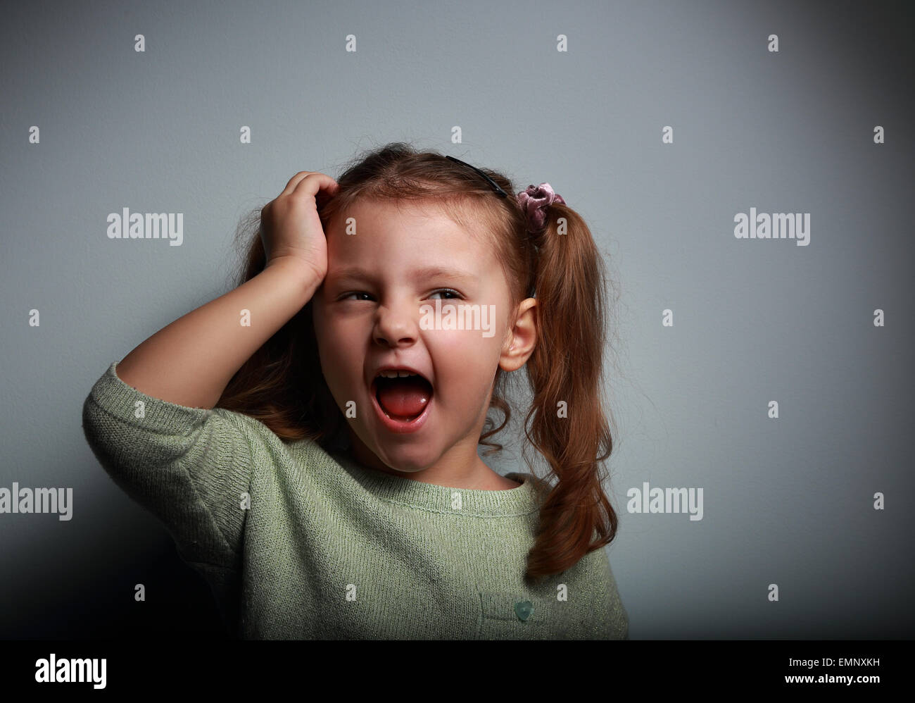 Crying sad kid girl holding hand the head on dark shadows background ...