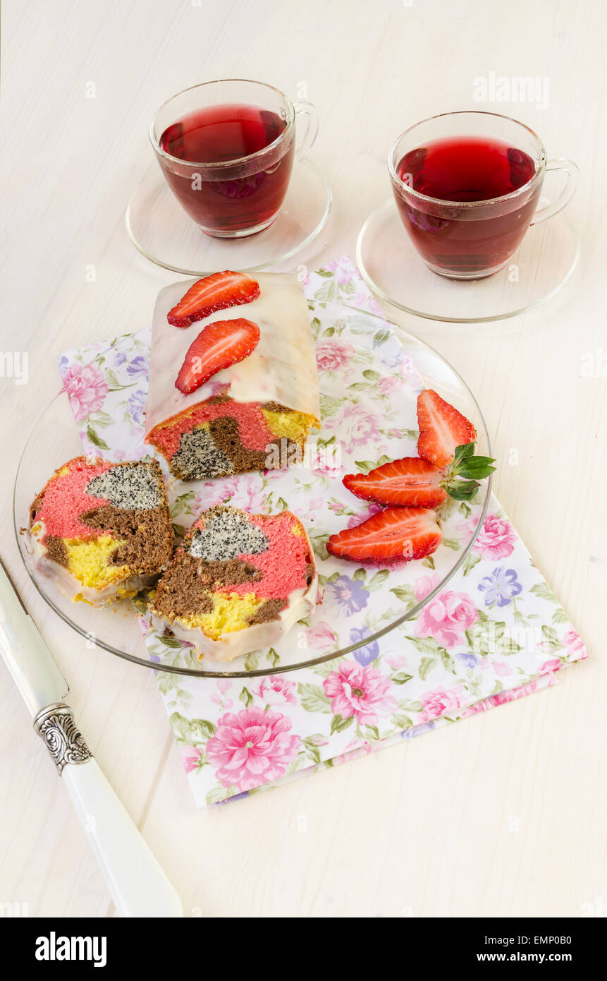 Strawberry poppy seed cake with white chocolate glaze on glass plate ...
