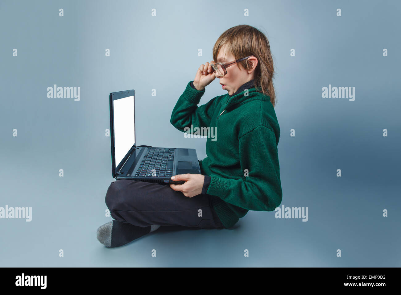 European-looking boy of ten years in glasses sitting looking at a ...
