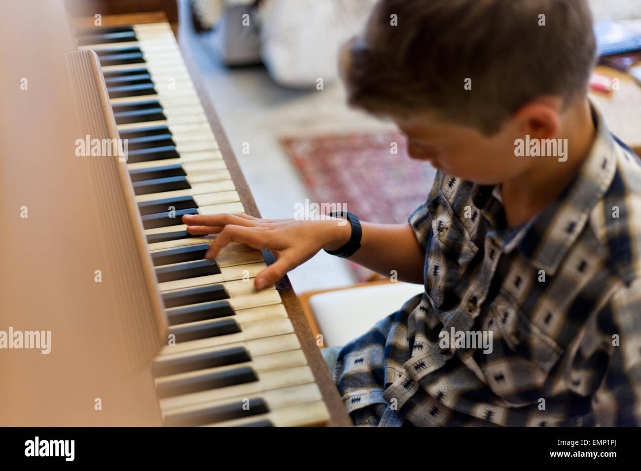 Young boy playing piano in a liviing room Stock Photo - Alamy