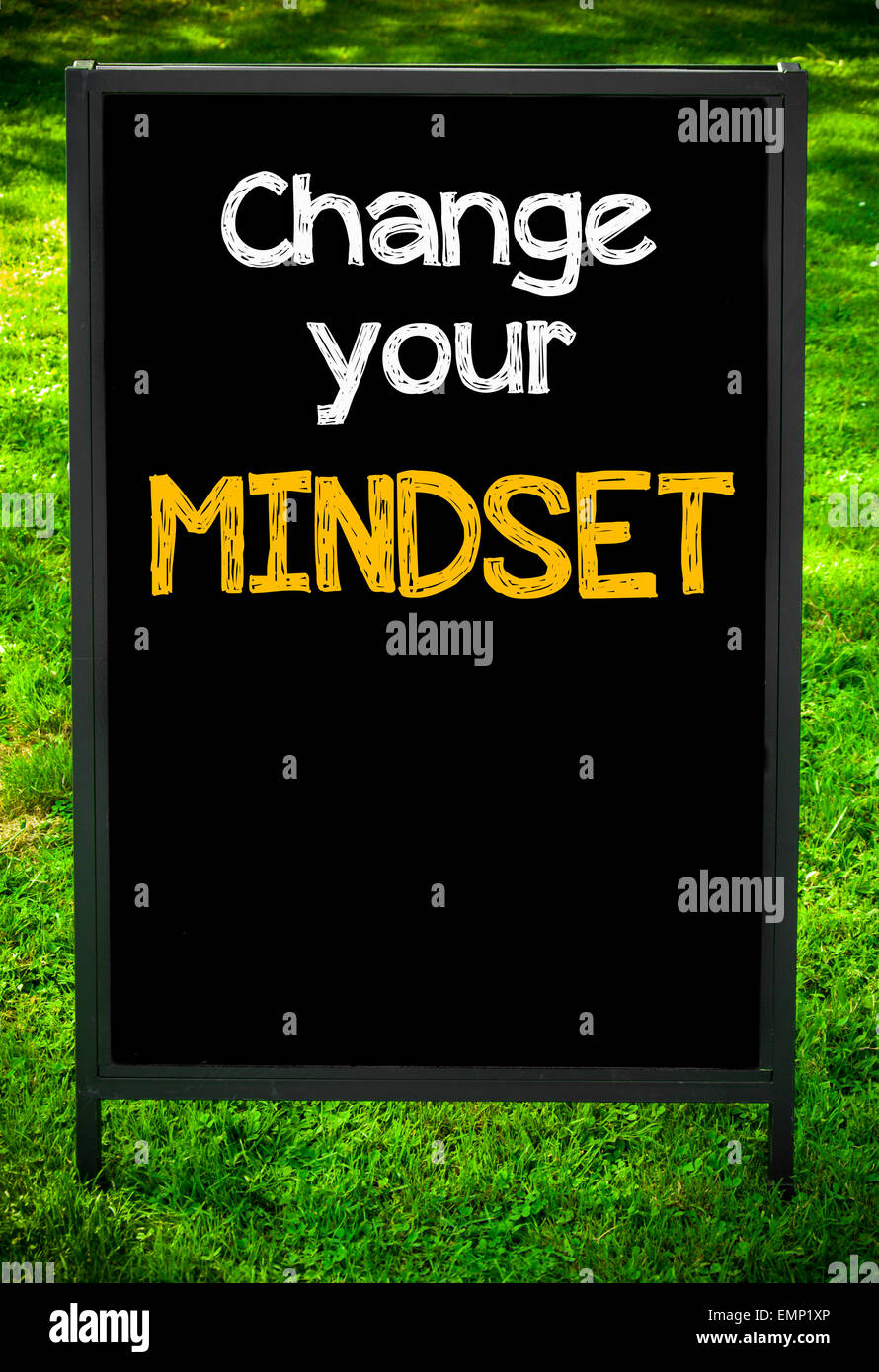 CHANGE YOUR MINDSET message on sidewalk blackboard sign against green ...