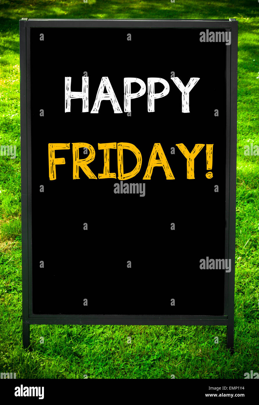 HAPPY FRIDAY message on sidewalk blackboard sign against green grass ...