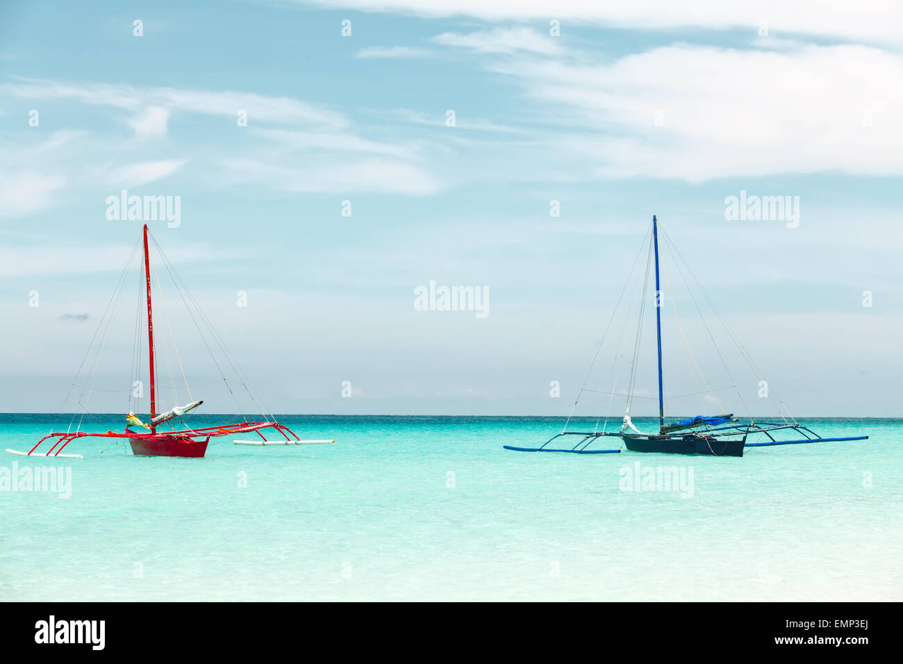 Red and blue motor boat on horizon of deep blue sea. Big white clouds ...